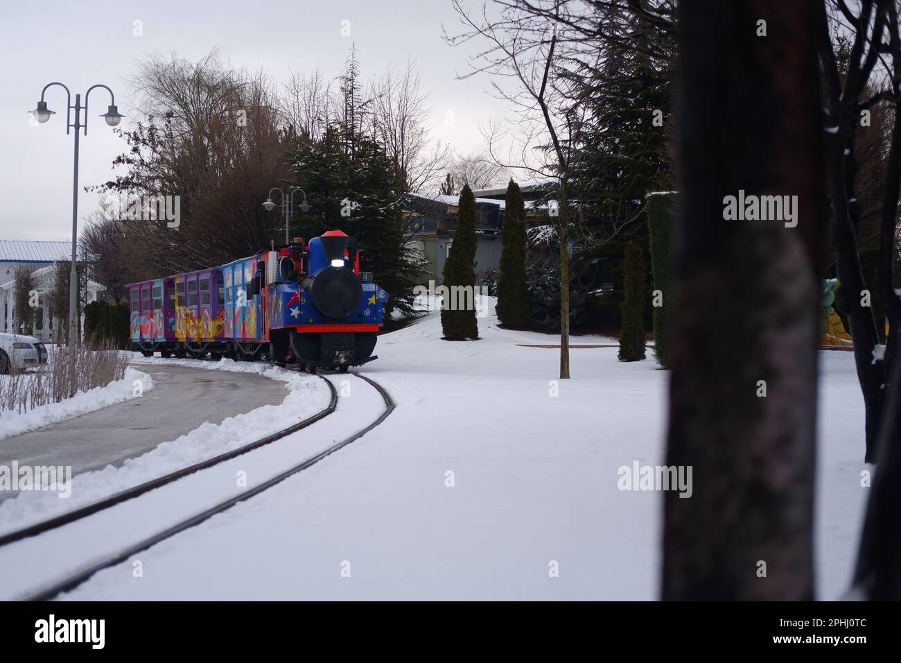 Colorful vintage train approaching through a turn within trees under ...