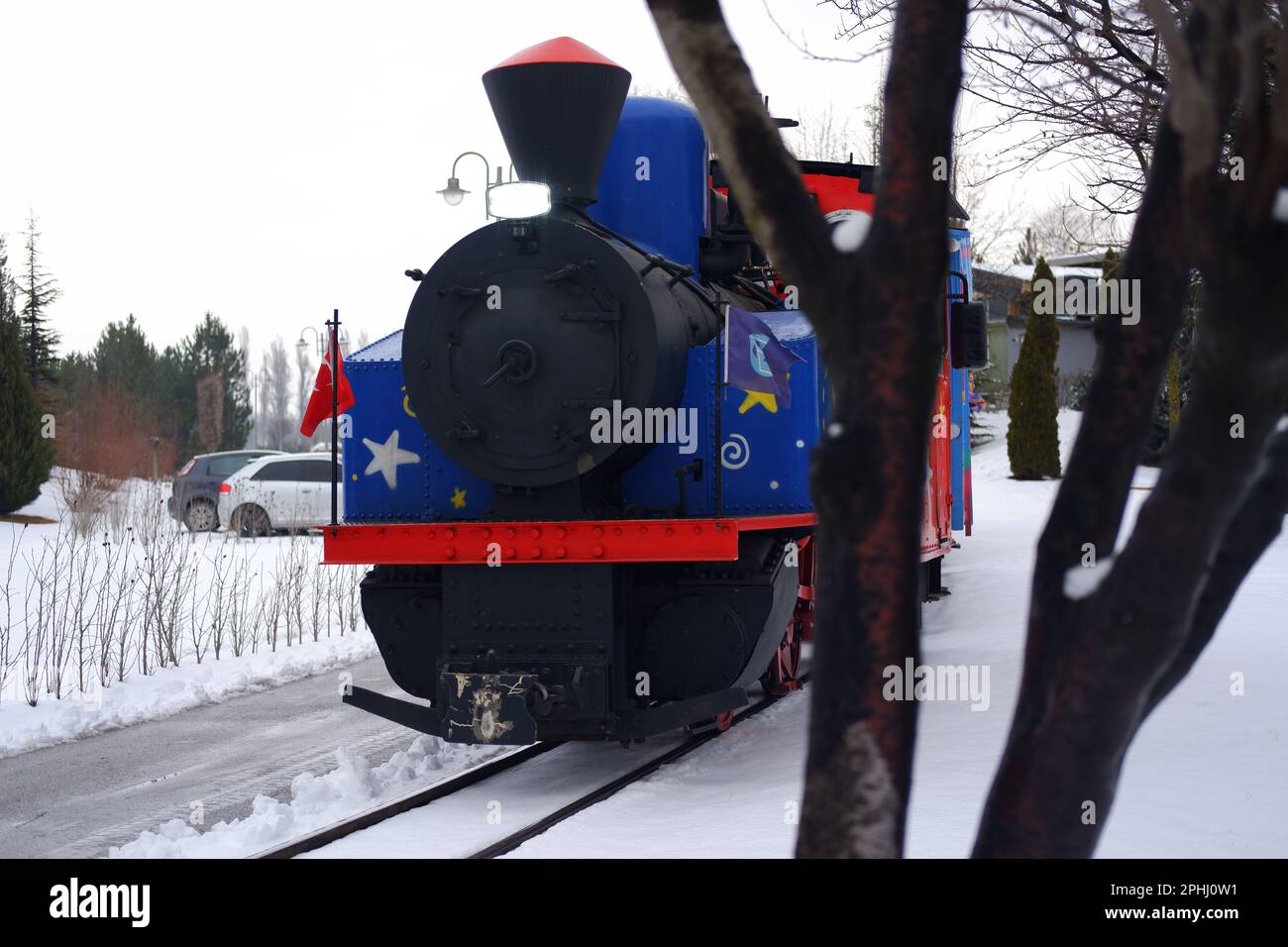 Colorful train for approaching within trees under snow in a winter day ...
