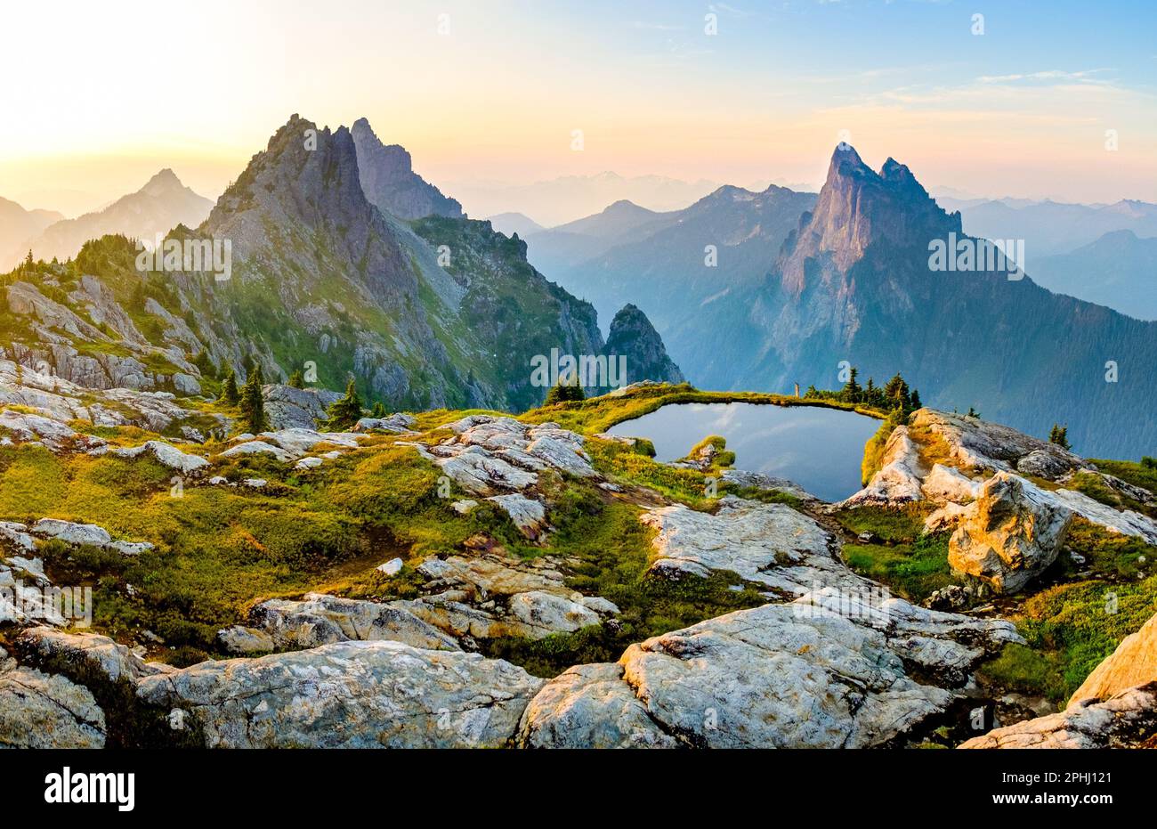 Sunrise Illuminates an Alpine Lake and Mountain Summits Near the Town ...