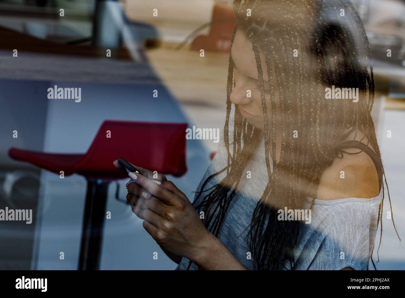 From outside looking in through the glass window: A girl with box ...