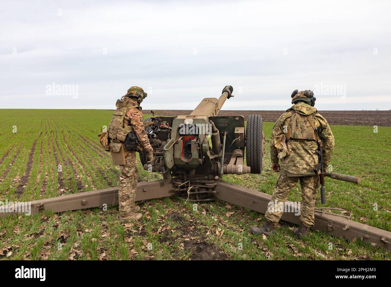 An artillery crew waits for instructions from the squad leader and ...