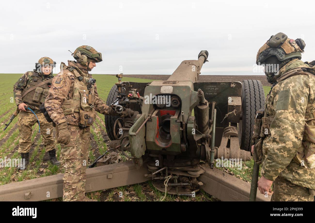 An artillery crew waits for instructions from the squad leader and ...