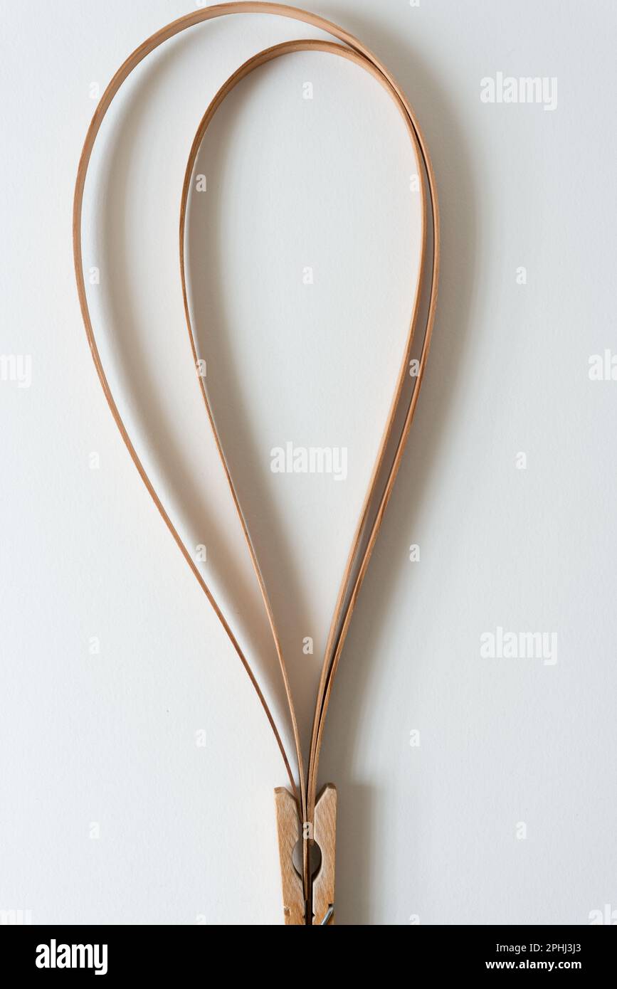 two pieces of thin wood straps bent and held in place with a clothes ...