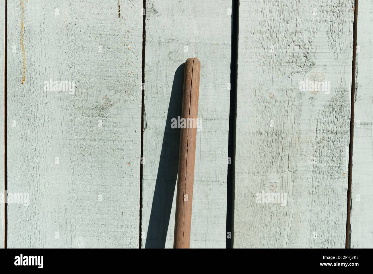 wooden object (handle or pole) resting on the side of a wooden shed ...
