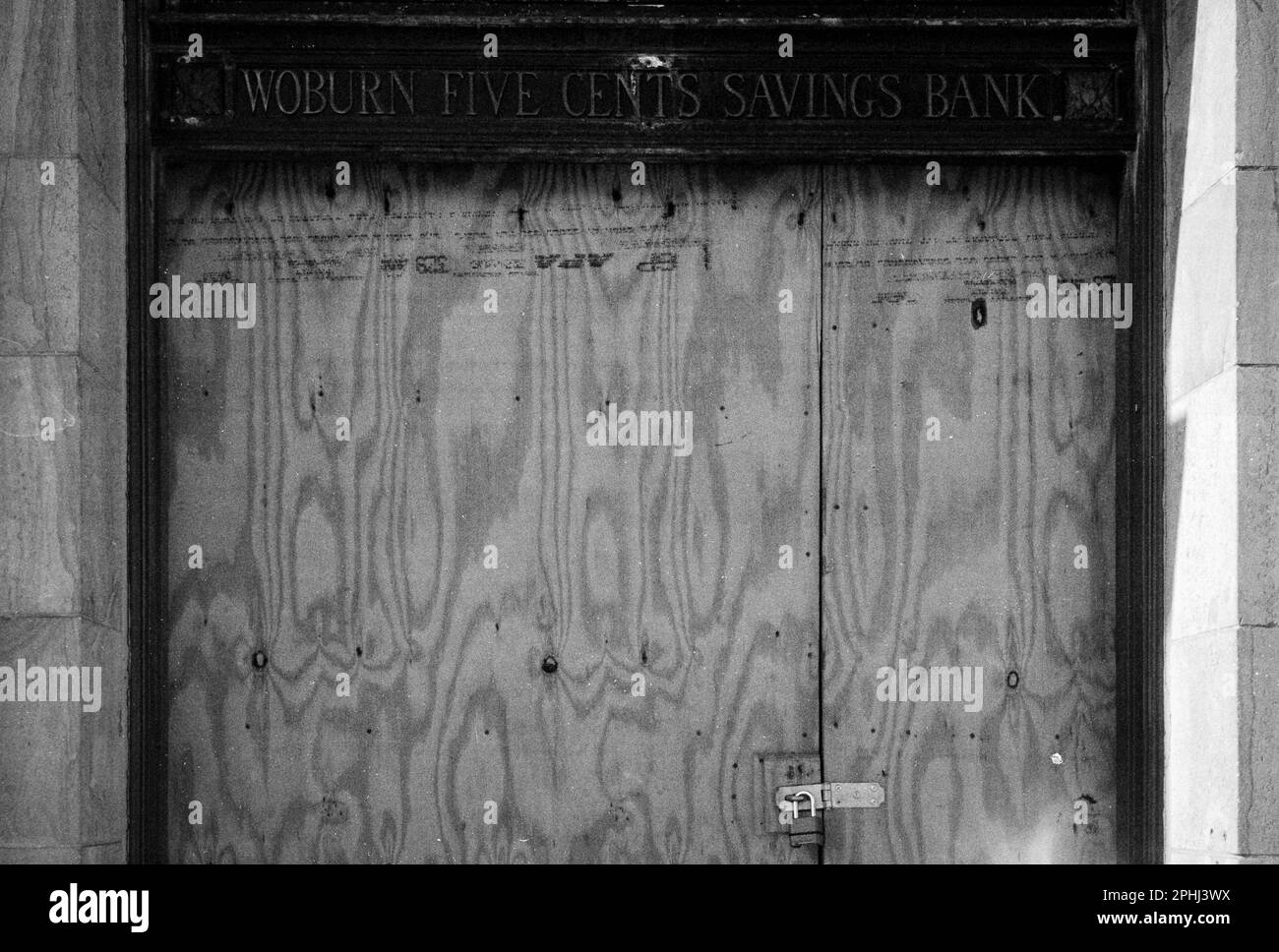 The Woburn Five Cent Savings Bank closed and boarded up with a padlock ...