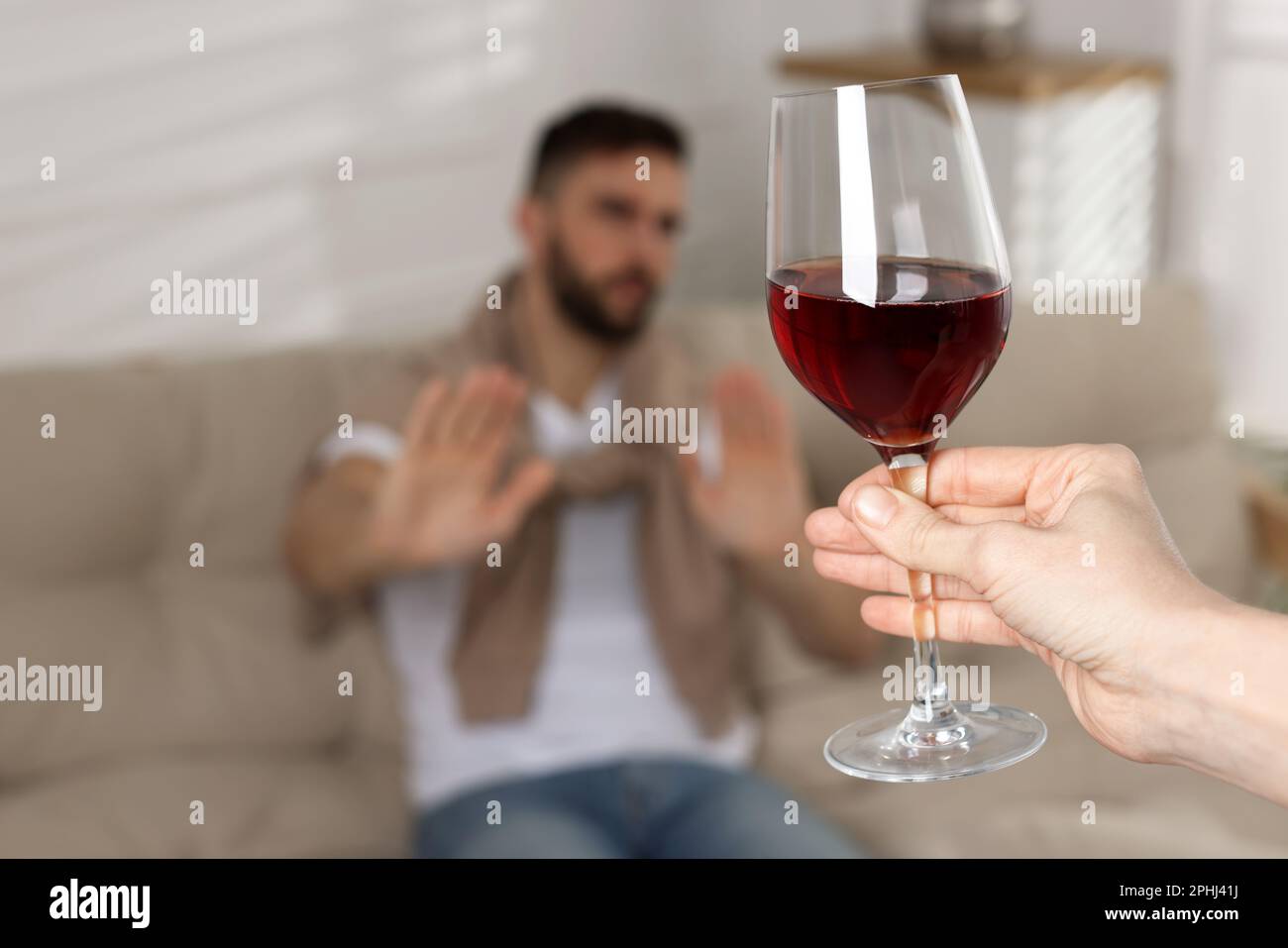 Man refusing to drink red wine indoors, closeup. Alcohol addiction ...