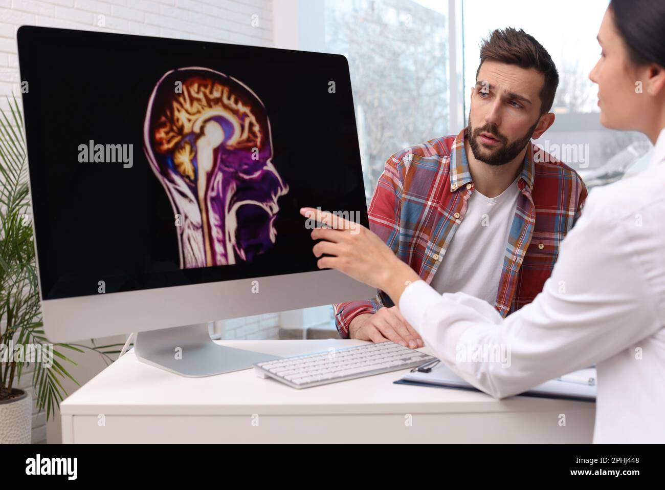 Neurologist showing brain scan to sad man in clinic Stock Photo - Alamy