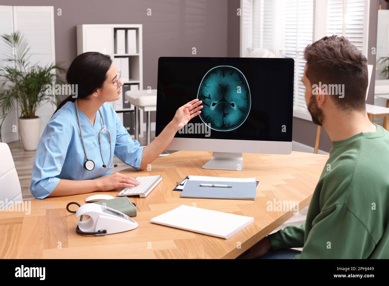 Neurologist showing brain scan to patient in clinic Stock Photo - Alamy