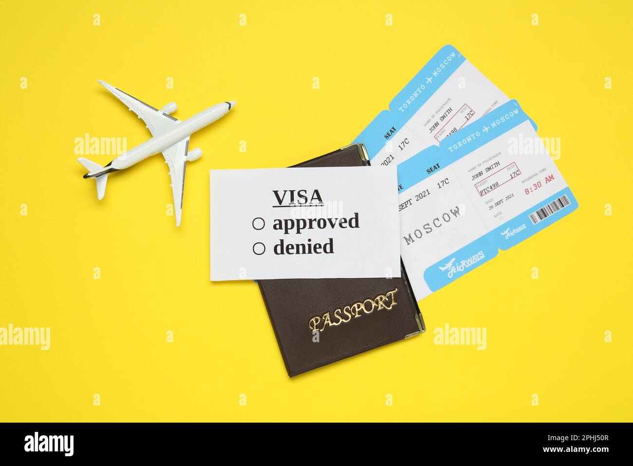 Flat lay composition with passport, toy plane and tickets on yellow ...