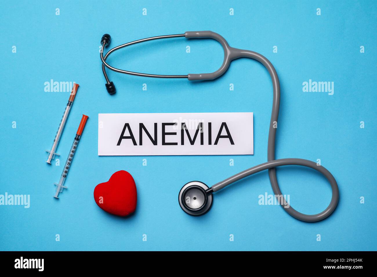 Card with word Anemia, stethoscope, syringes and decorative heart on ...