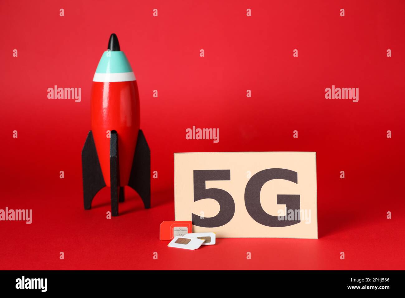Internet concept. Paper with phrase 5G, toy rocket and SIM cards on red ...