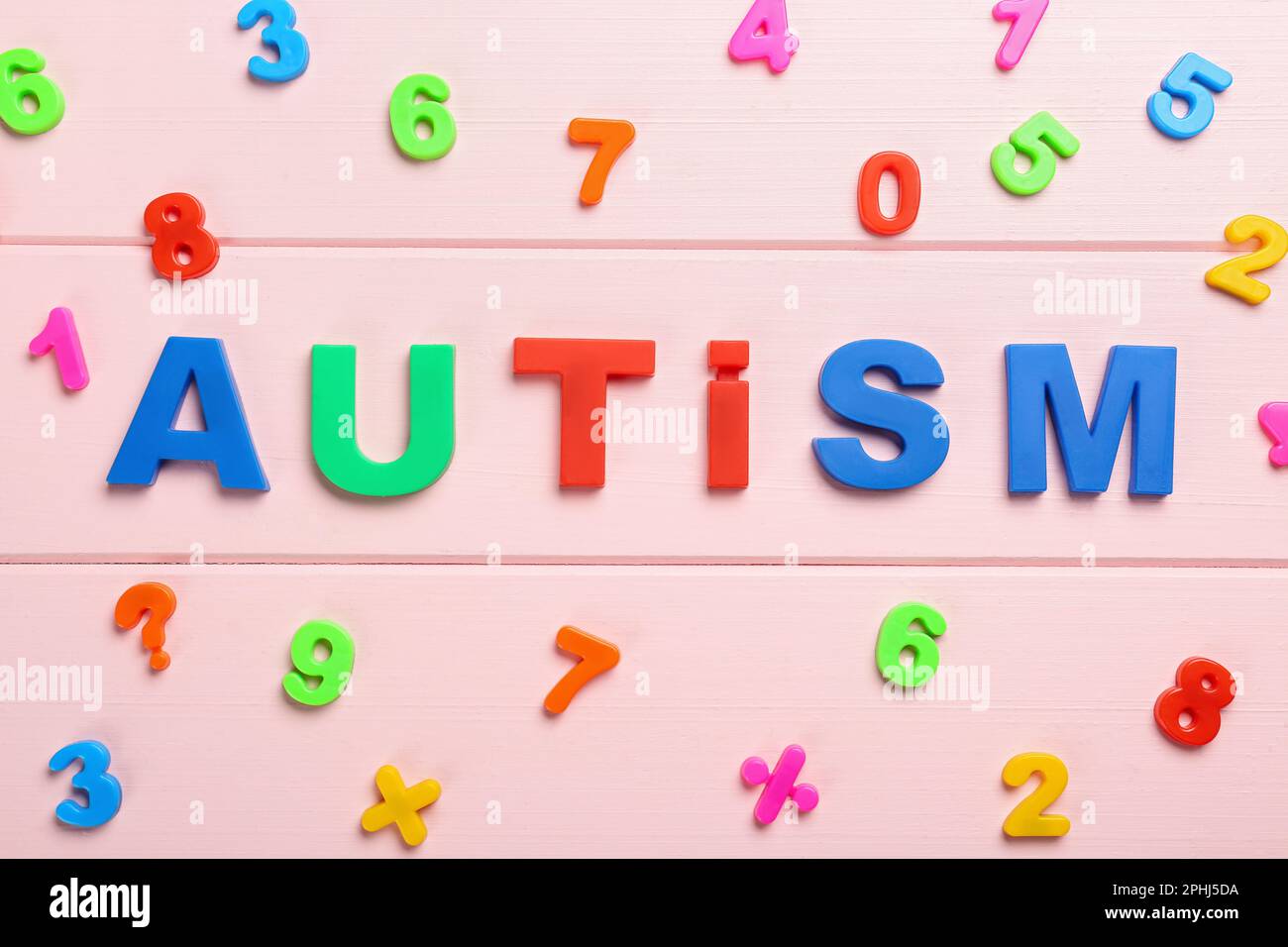 Flat lay composition with colorful numbers and word Autism on pink ...
