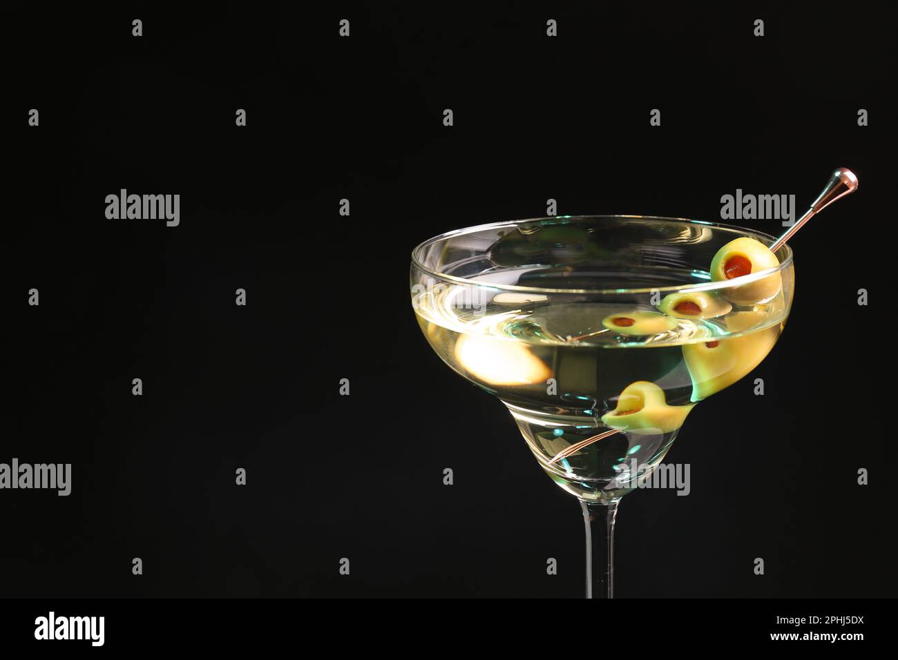 Martini cocktail with olives on dark background, closeup. Space for ...