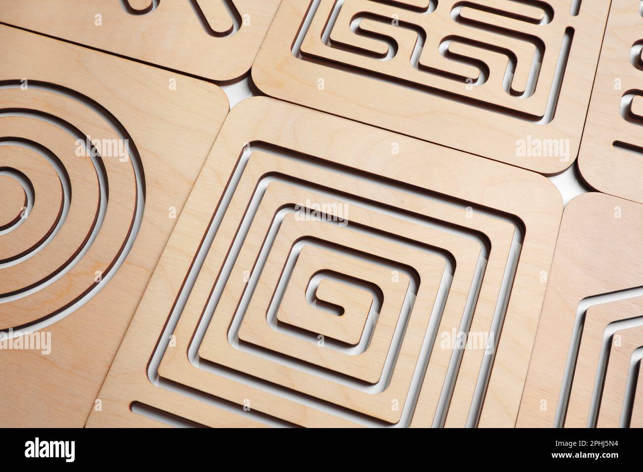 Wooden finger labyrinths on white background, closeup. Montessori toy ...