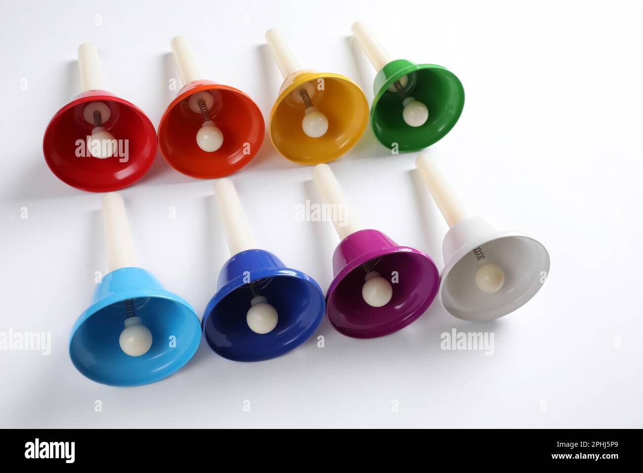 Set of bright metal hand bells on white background. Montessori musical ...