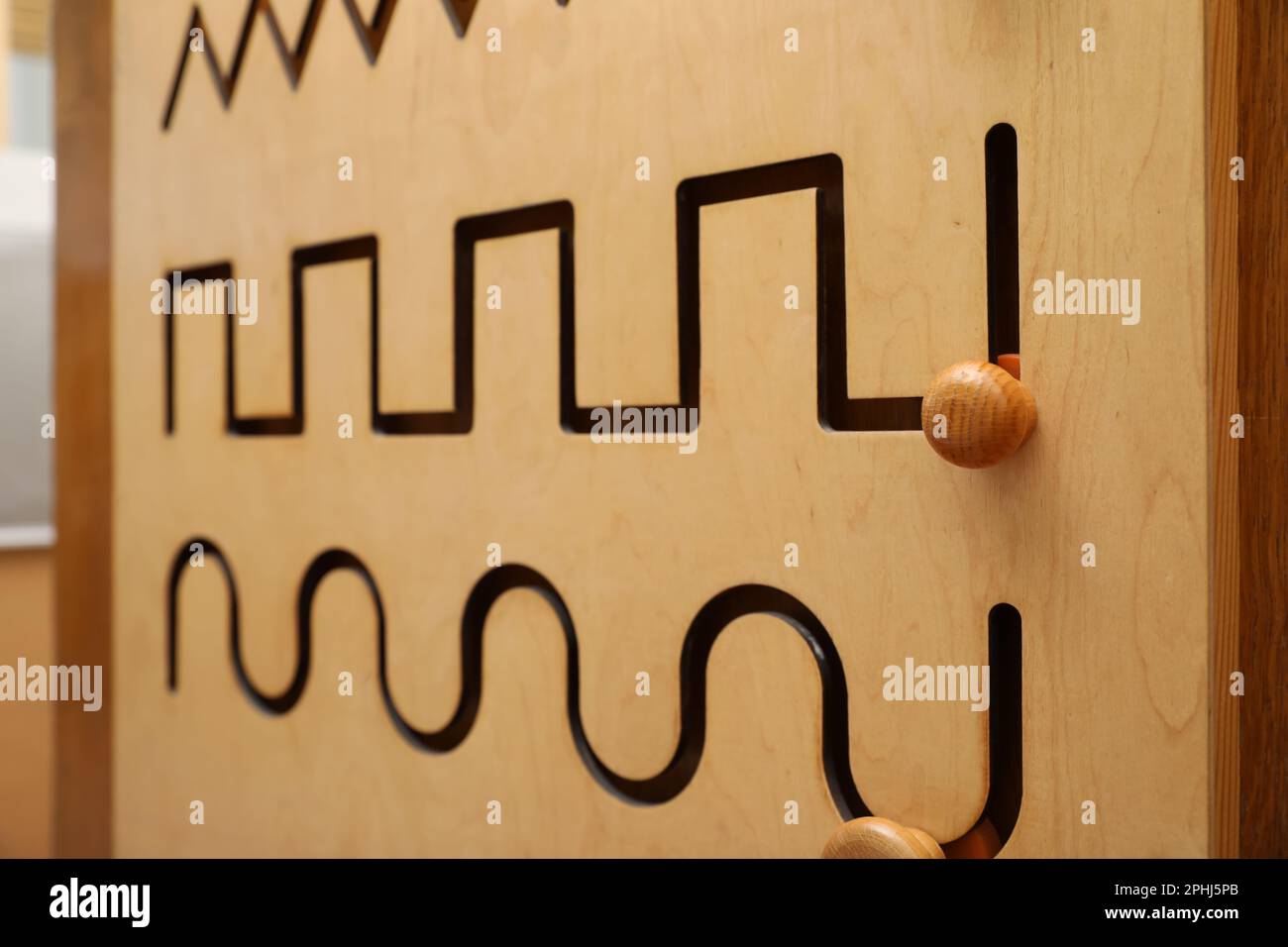 Wooden sliding maze with different lines on wall, closeup. Montessori ...