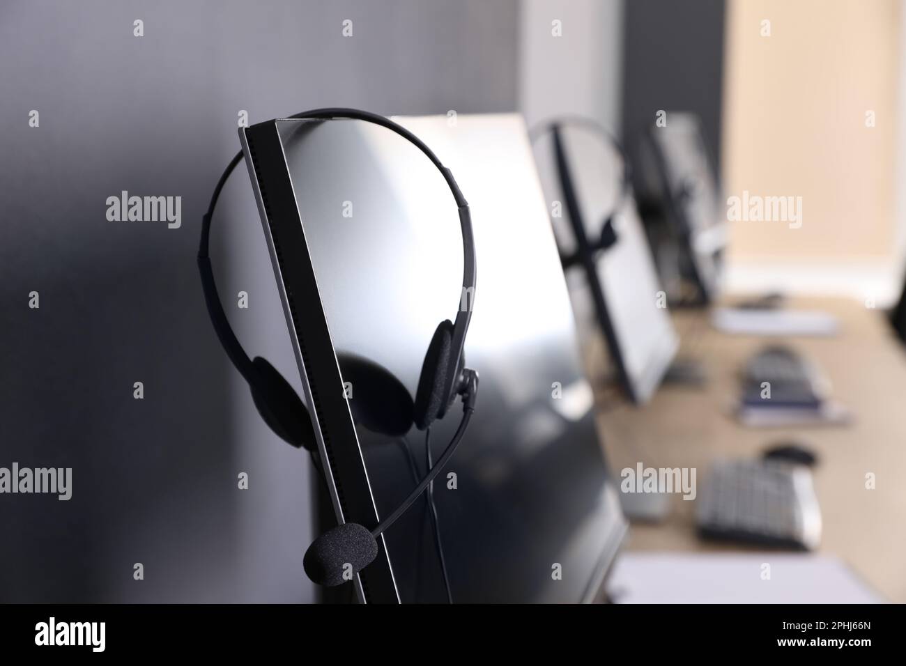 Modern computer with headset in office. Hotline service Stock Photo - Alamy
