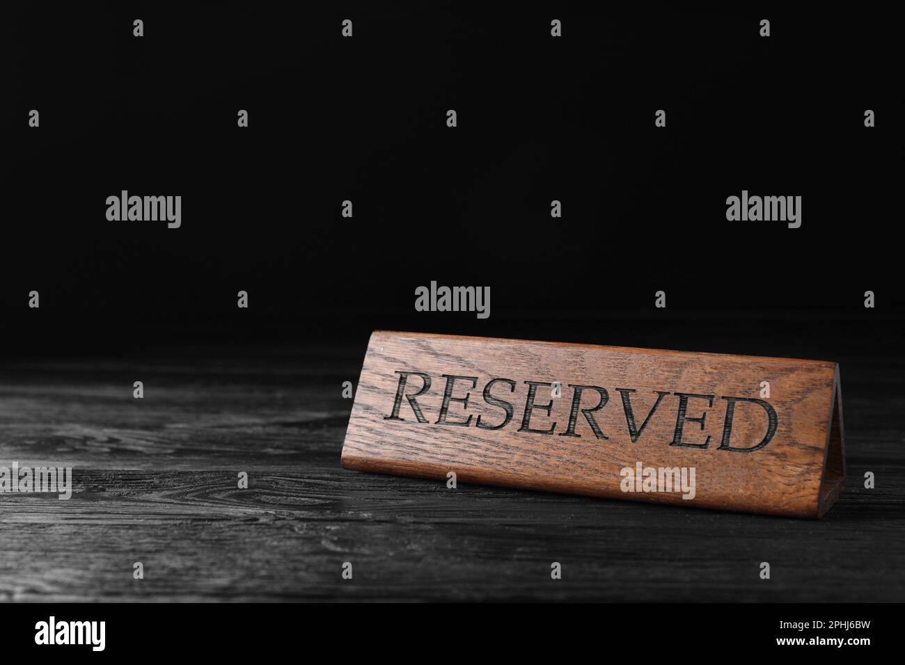 Elegant wooden sign RESERVED on black table, space for text Stock Photo ...