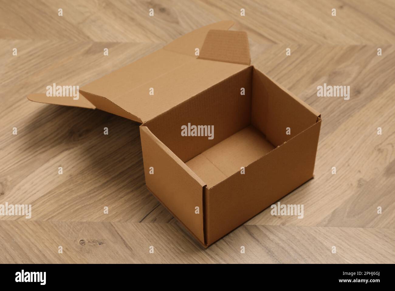 One empty open cardboard box on floor Stock Photo - Alamy