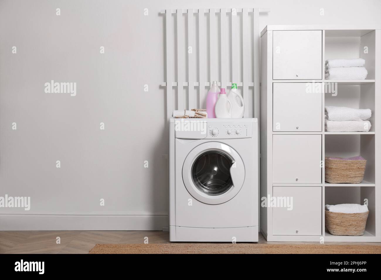 Laundry room interior with modern washing machine and shelving unit ...