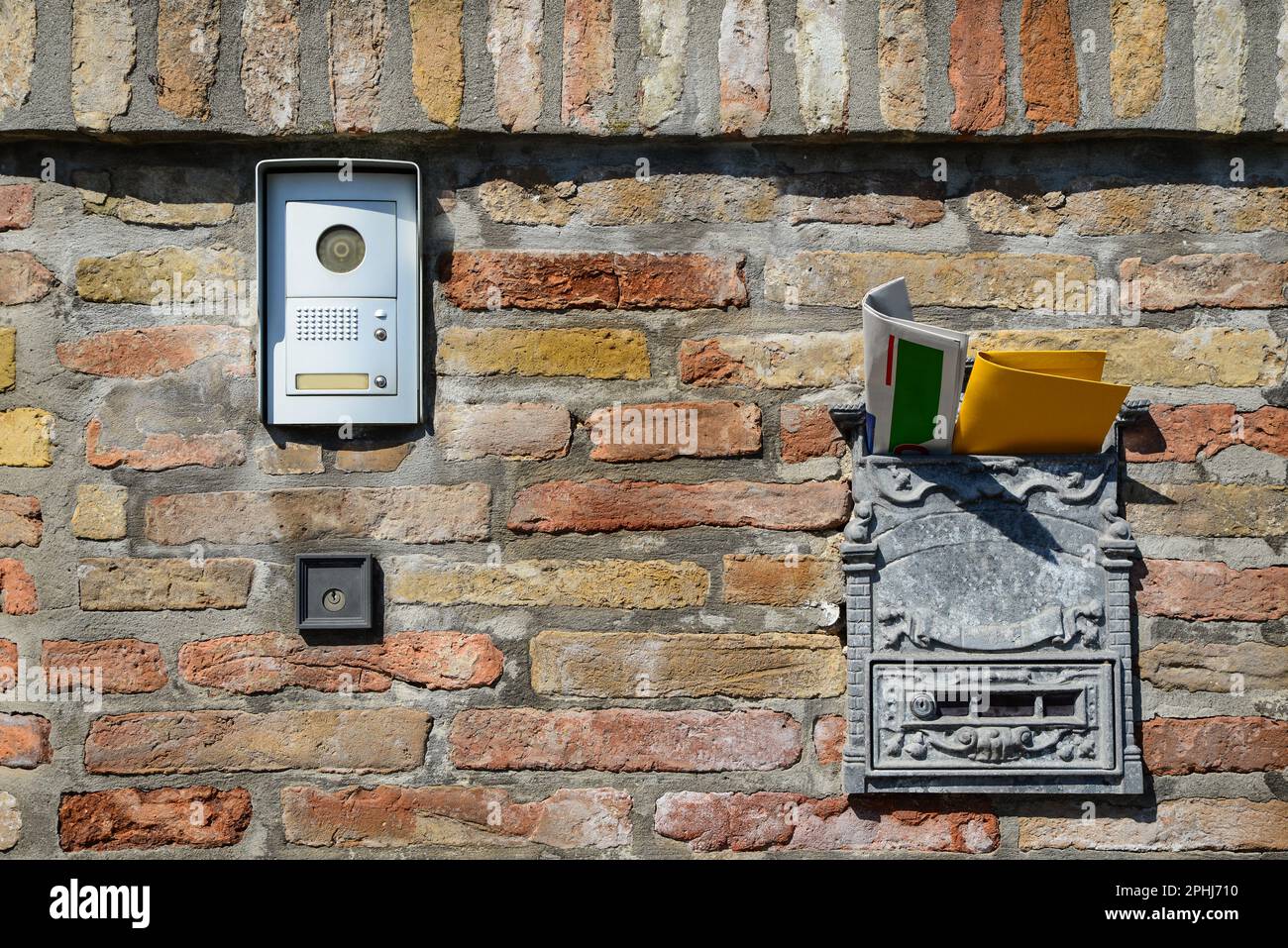 Vintage post box with newspaper and letter near modern intercom on old ...
