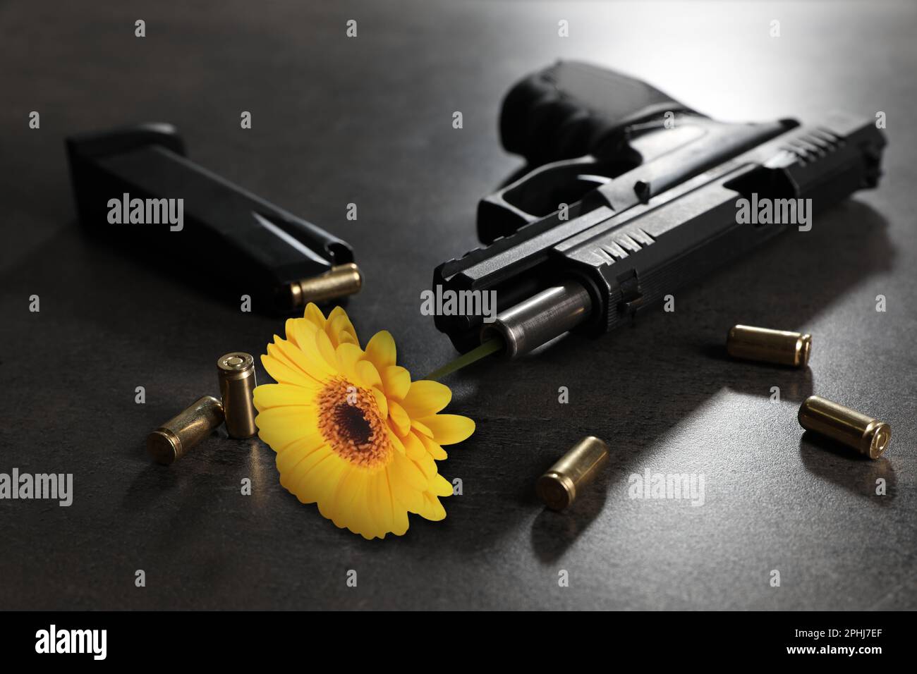 Beautiful flower, bullets and handgun on grey table. Peace instead of ...