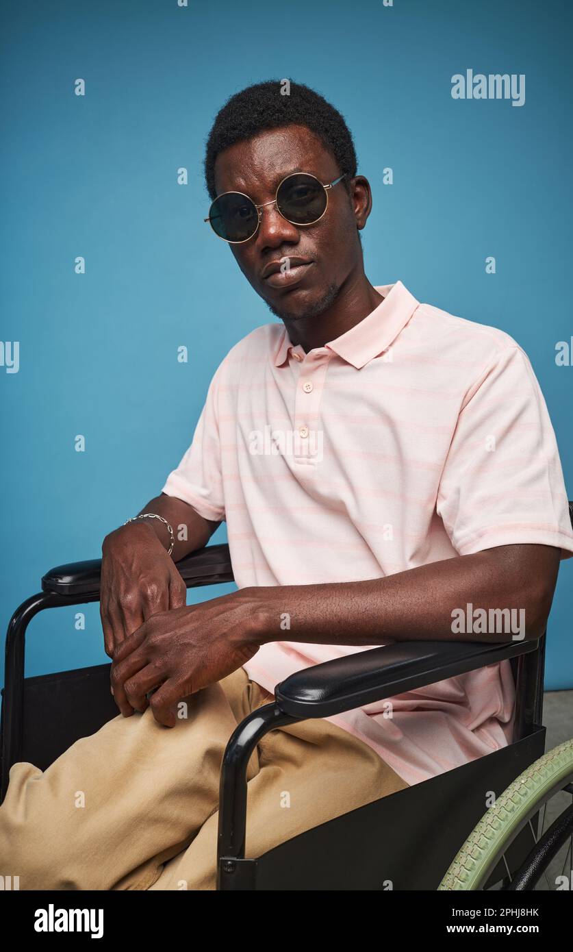Vertical portrait of fashionable black man with disability wearing ...