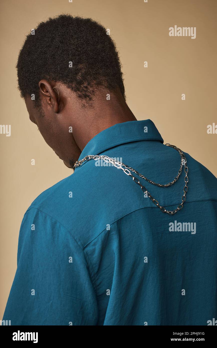 Vertical back view of young black man facing away from camera posing ...