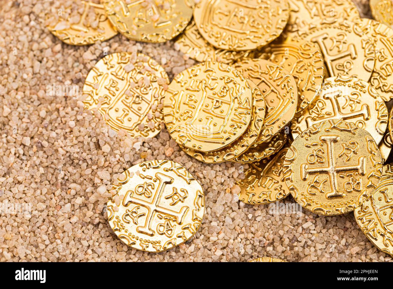 A Buried Pirate Treasure Gold Coins in the Sand on a Beach Stock Photo ...