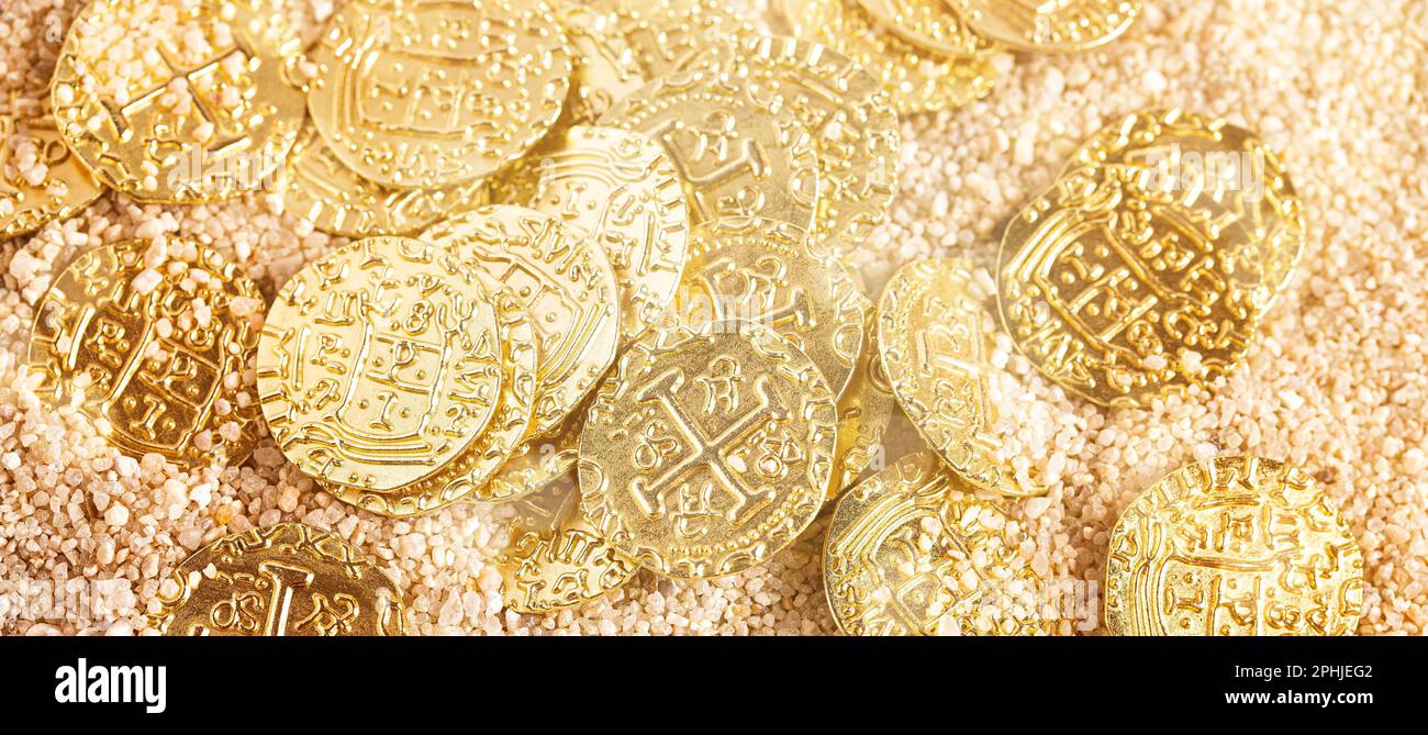 A Buried Pirate Treasure Gold Coins in the Sand on a Beach Stock Photo ...