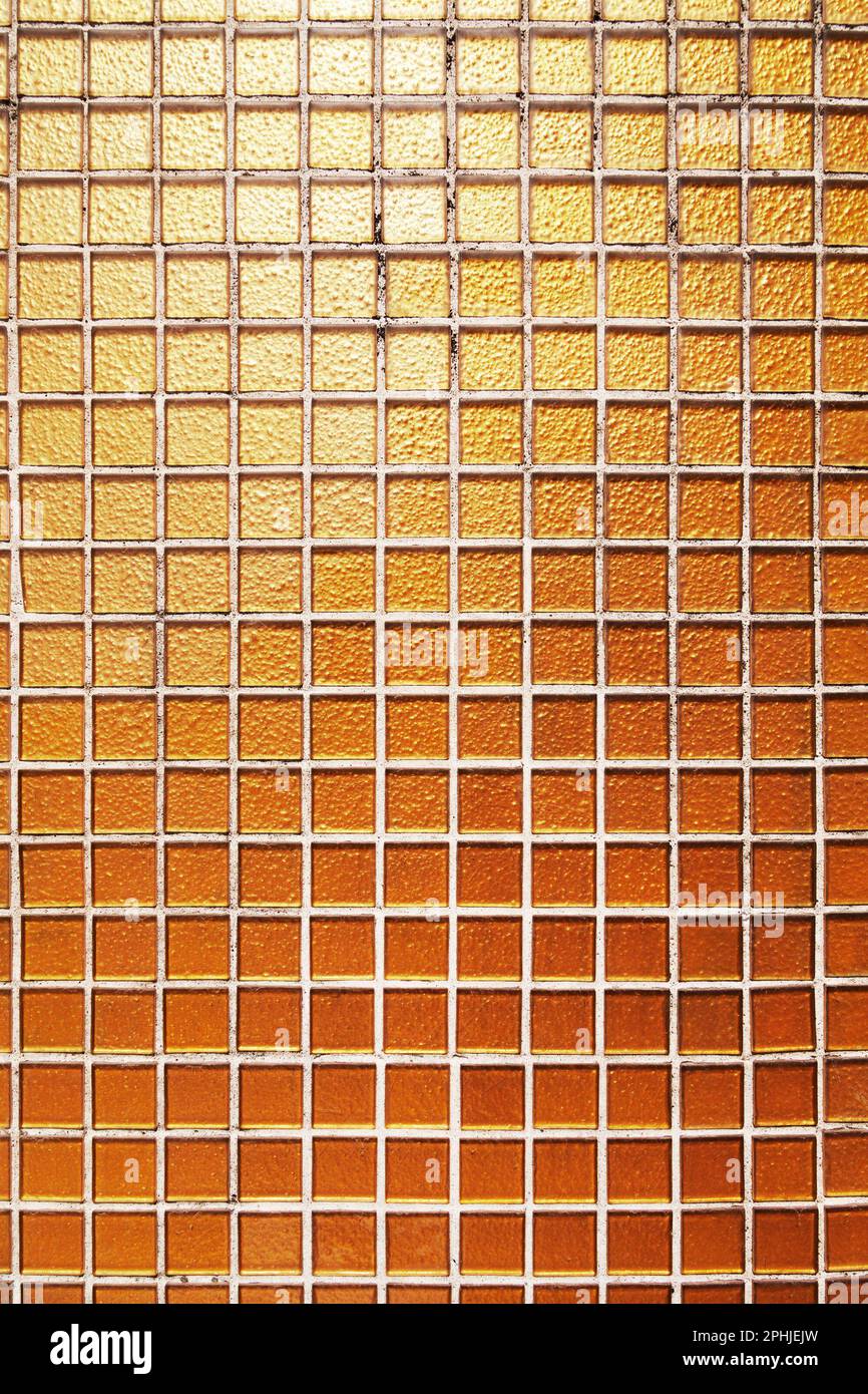 Building wall decorated with small square golden tiles. Orange glass ...