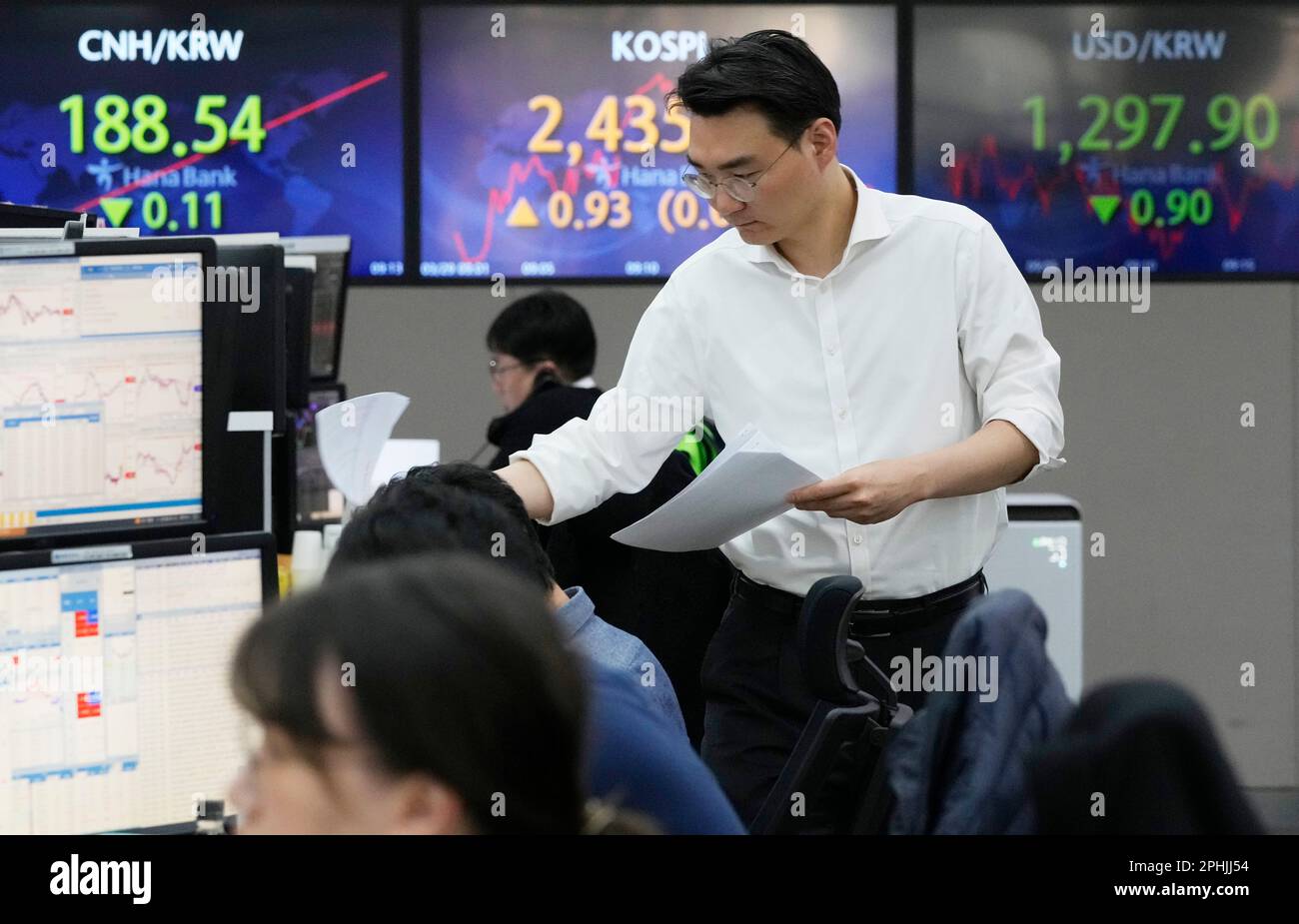 A currency trader works near the screens showing the Korea Composite ...