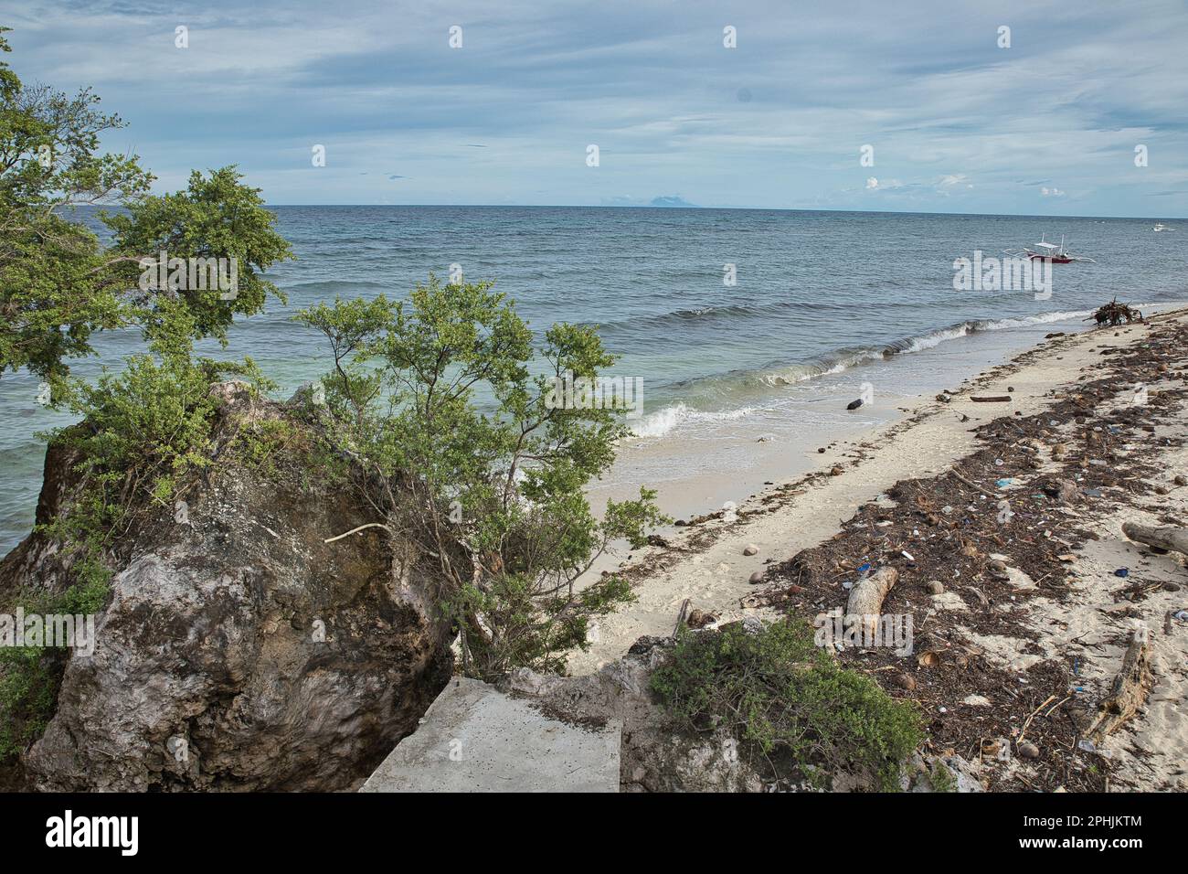 A lonely, littered beach of Pamilacan Island in the Philippines taken ...