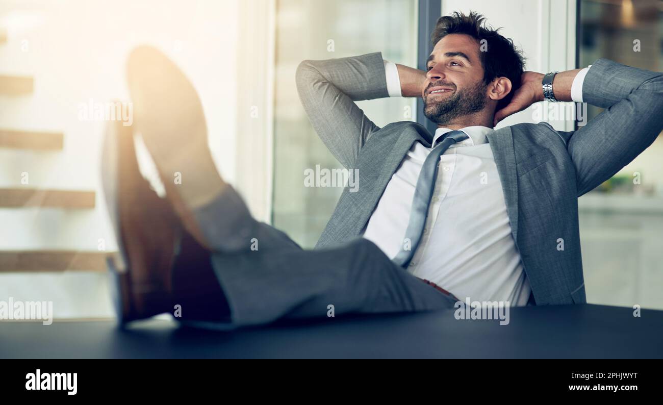 Taking a timeout in the office. a businessman leaning back in his chair ...