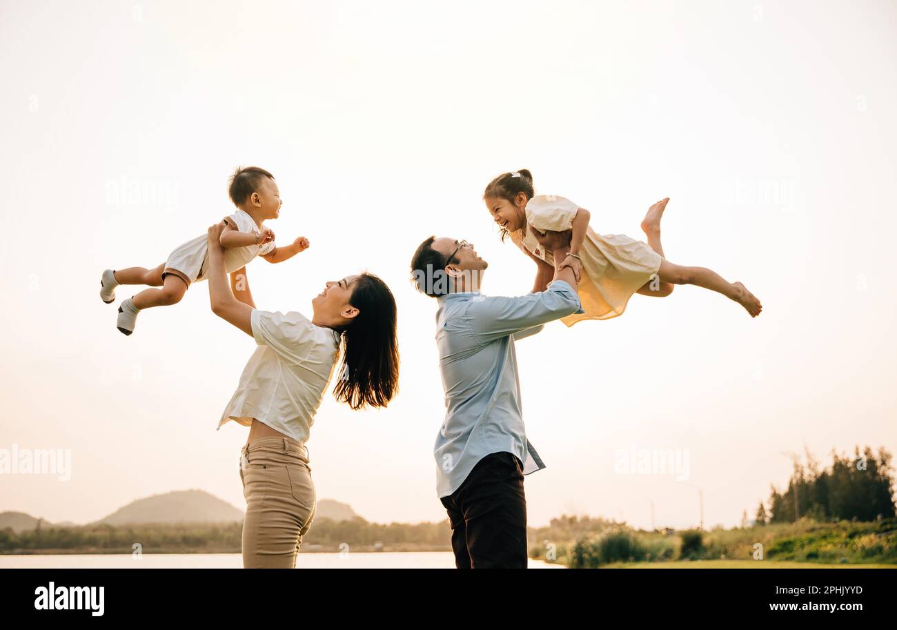 A happy family enjoys a playful moment in a summer field Stock Photo ...