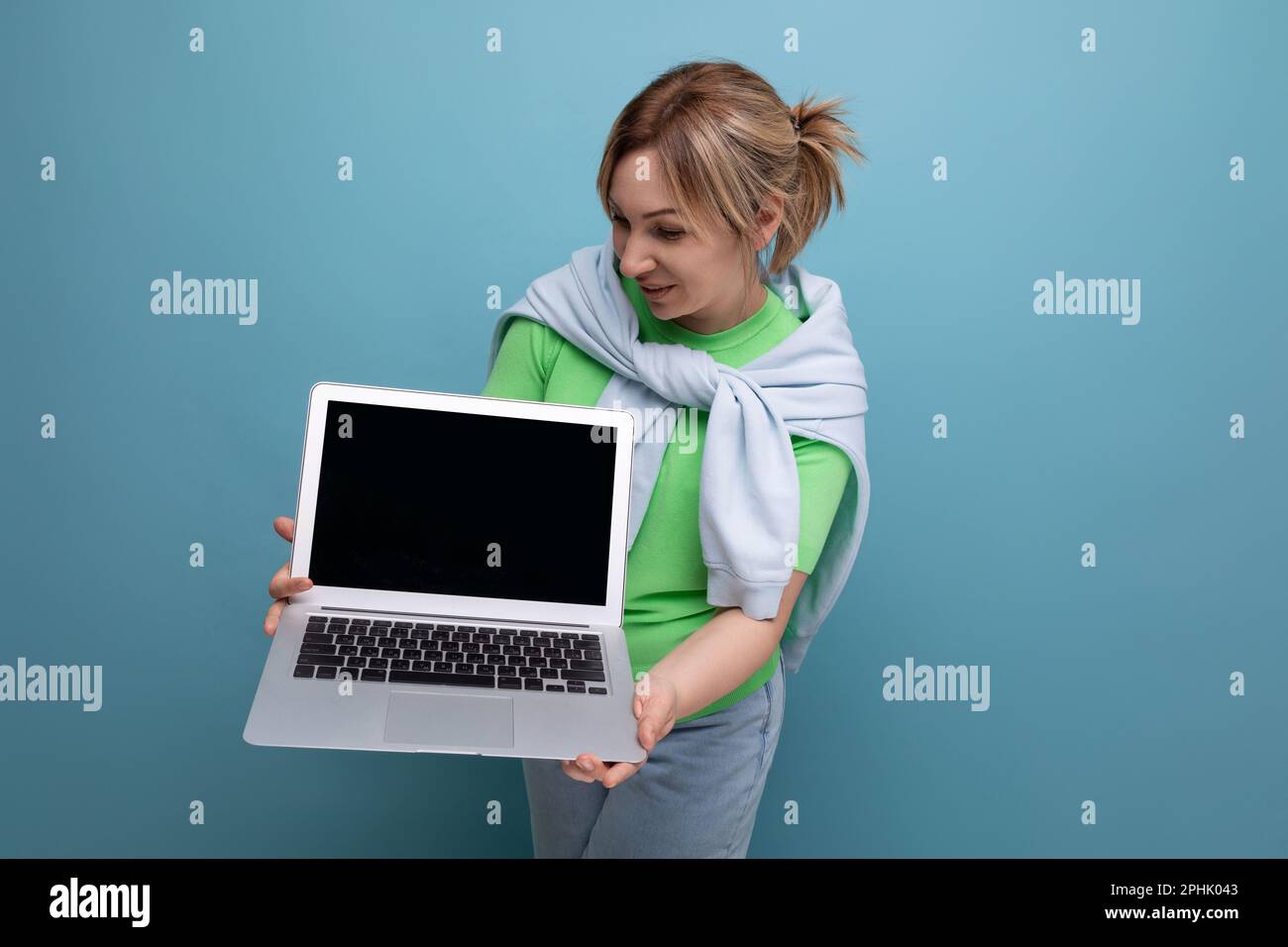 blond positive cute female freelancer in casual outfit showing screen ...