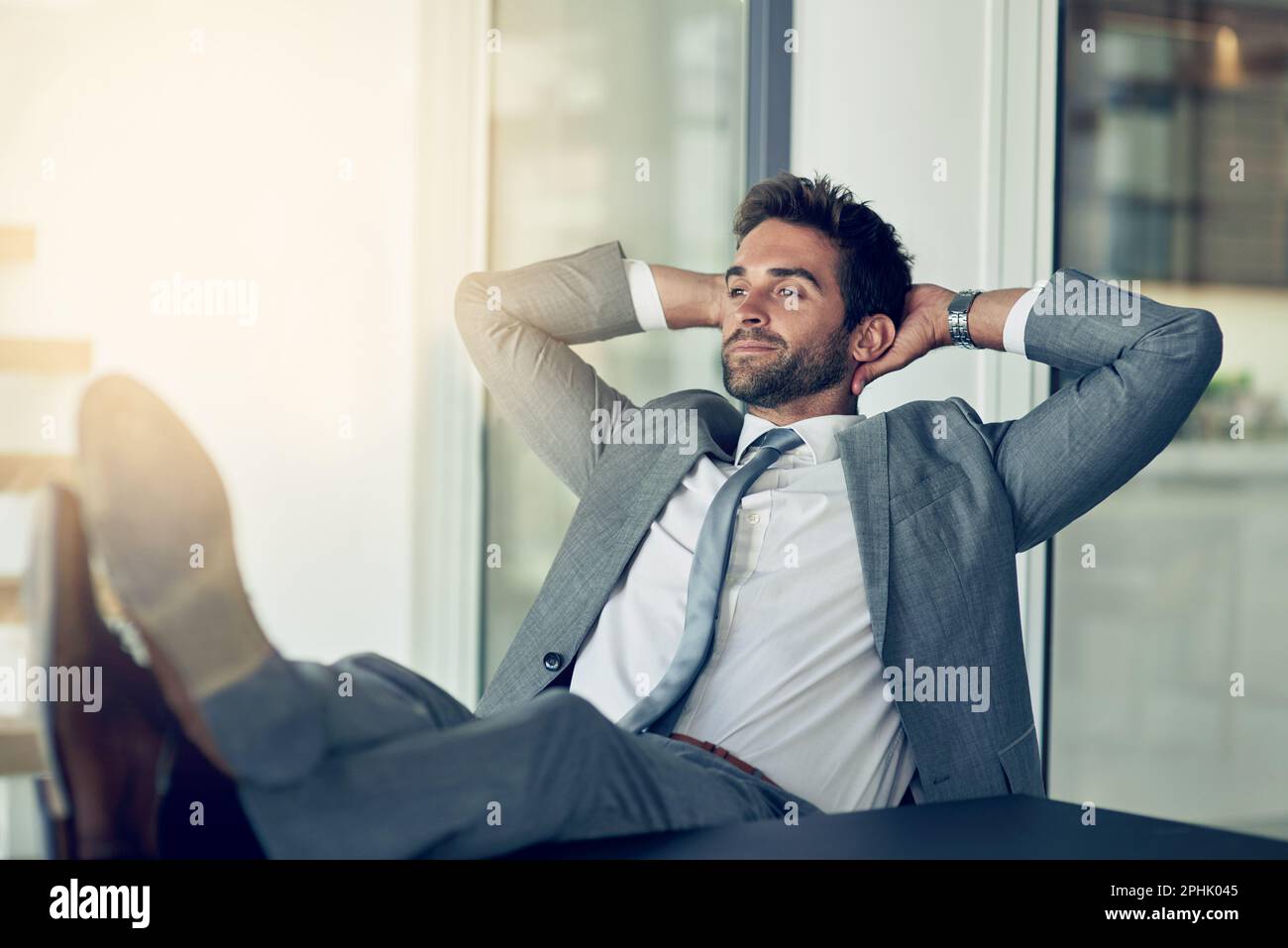 Time to bask in his success. a businessman leaning back in his chair ...