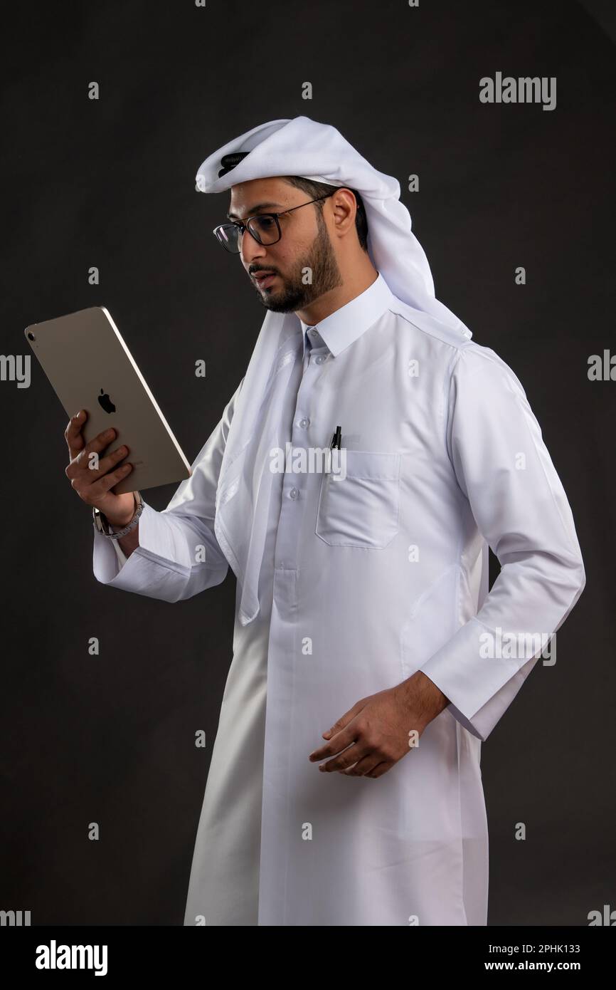 Qatari Man using Phone Tablet on isolated background. Business and ...