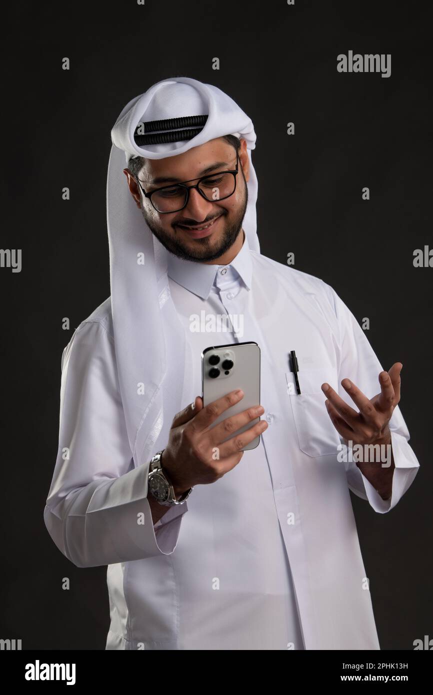 Qatari Man using Phone Tablet on isolated background. Business and ...