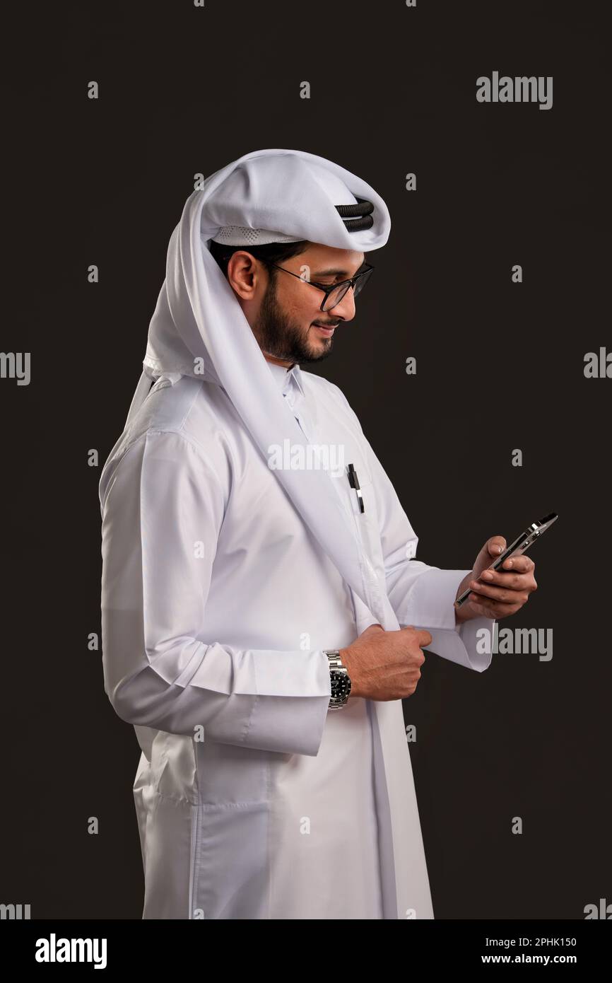 Qatari Man using Phone Tablet on isolated background. Business and ...