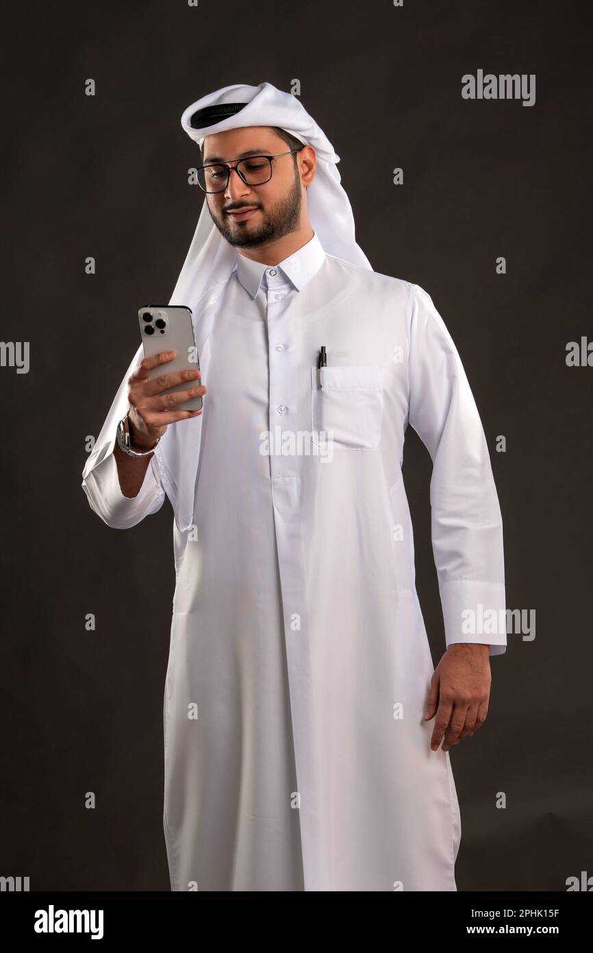 Qatari Man using Phone Tablet on isolated background. Business and ...