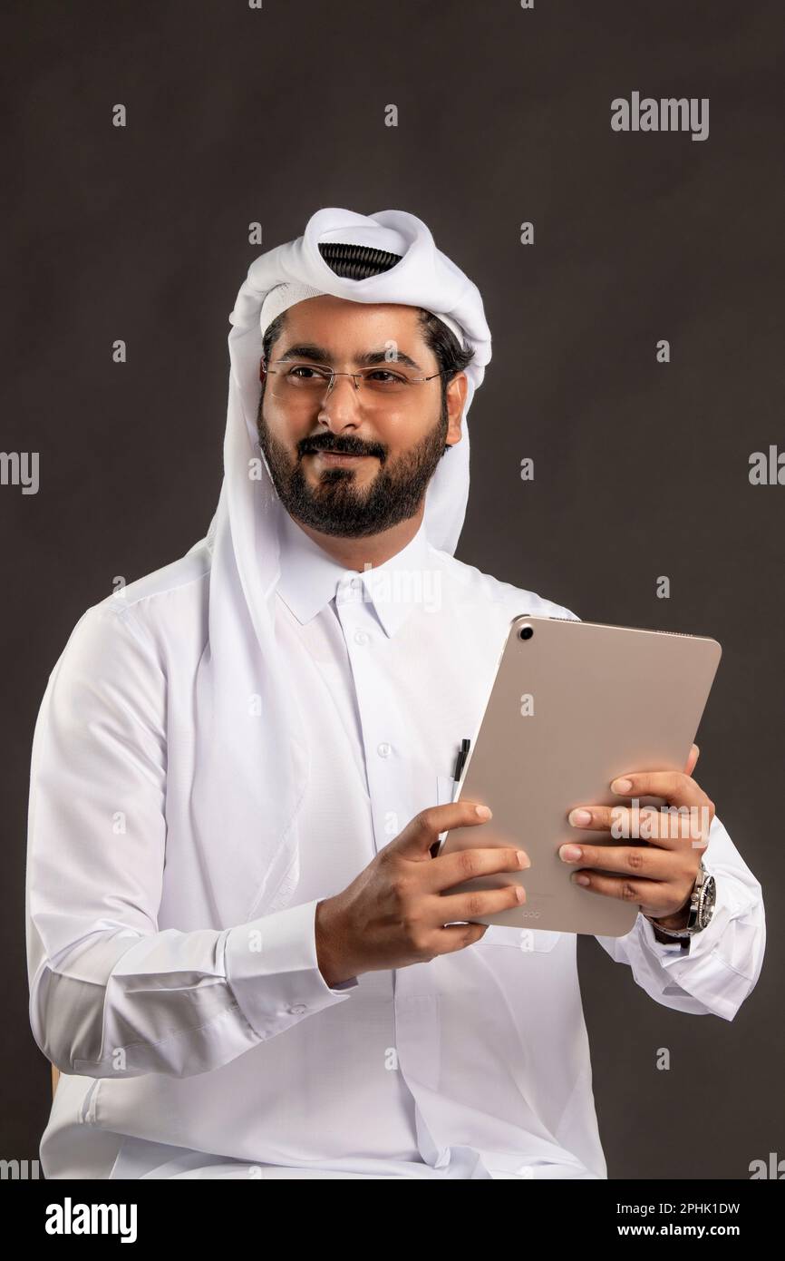 Qatari Man using Phone Tablet on isolated background. Business and ...