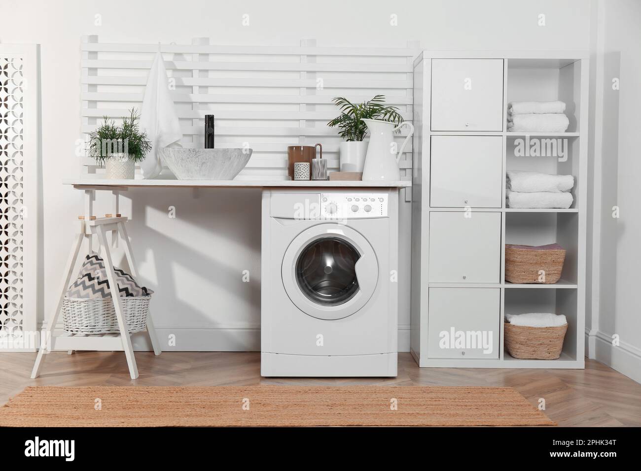 Laundry room interior with modern washing machine and shelving unit ...