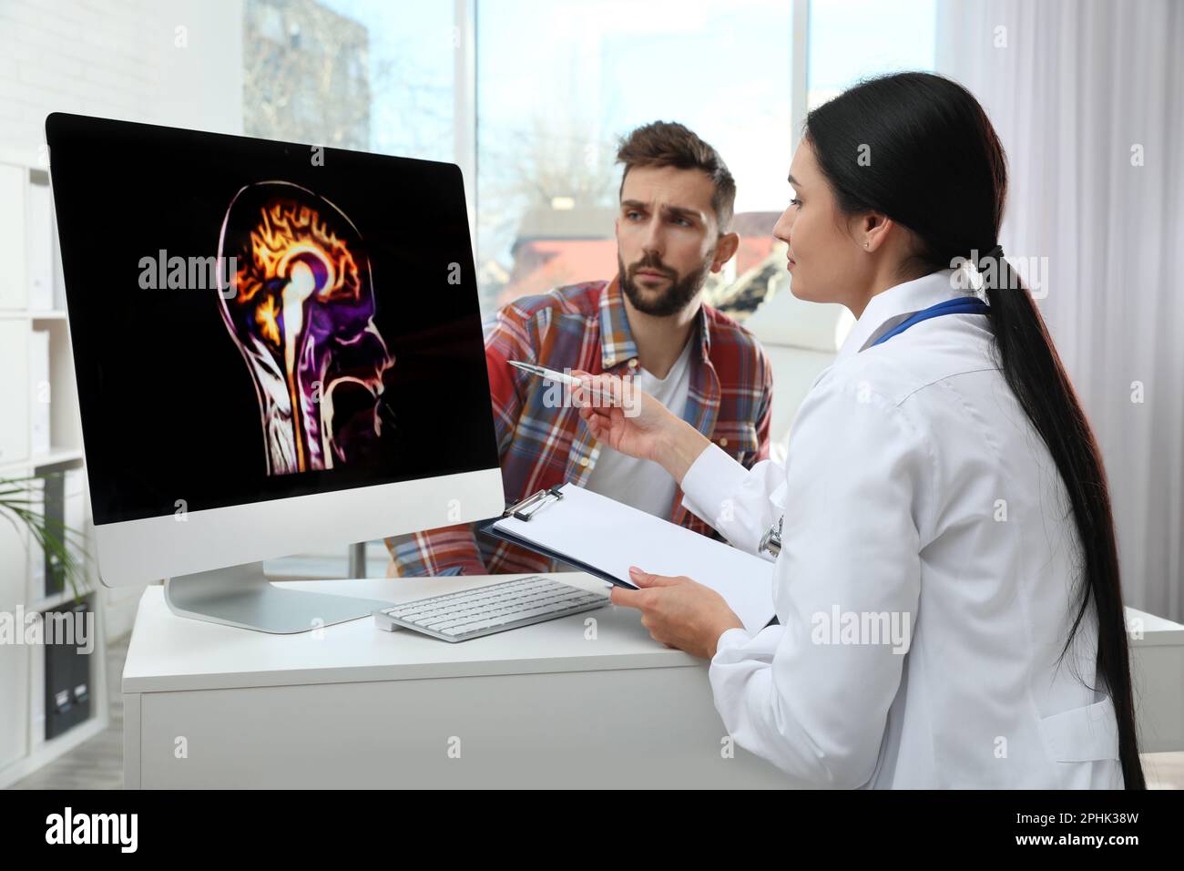 Neurologist showing brain scan to patient in clinic Stock Photo - Alamy