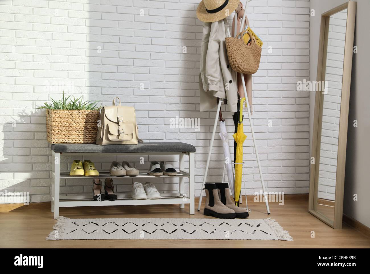 Stylish hallway interior with coat rack, shoe storage bench and mirror ...