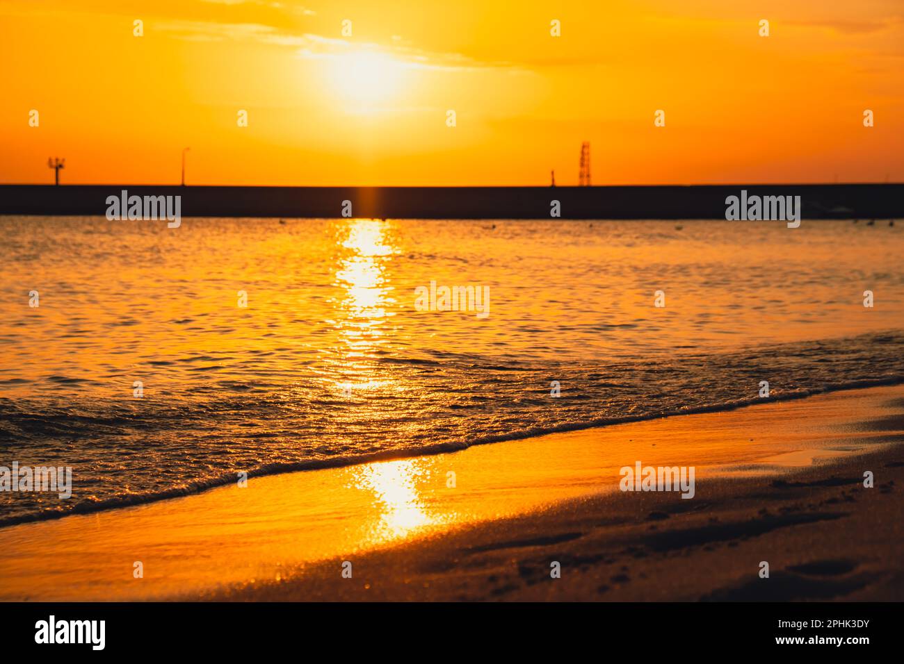 Reflection of sunlight over sea surface at sunset. Orange and gold blue ...