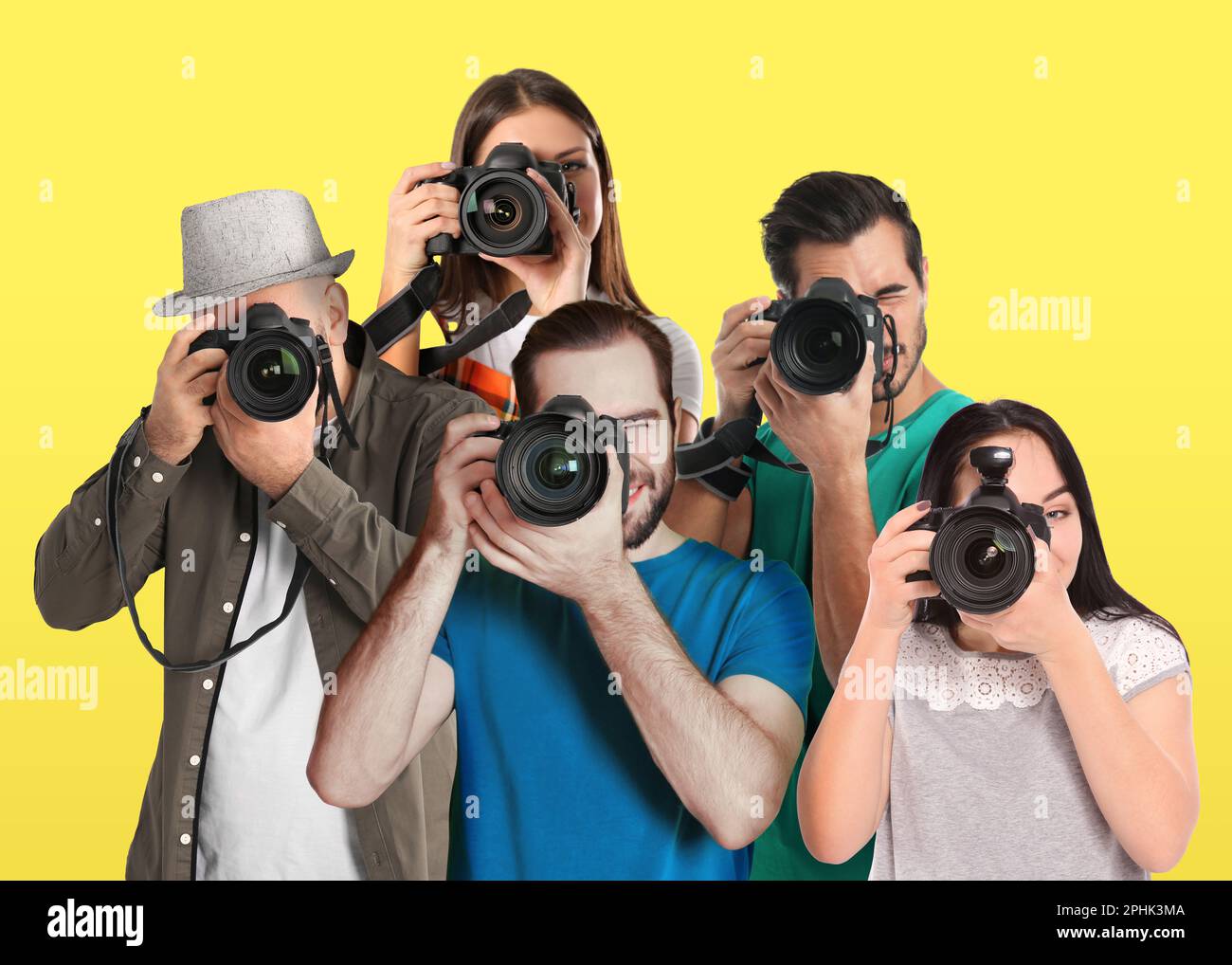 Group of professional photographers with cameras on yellow background ...