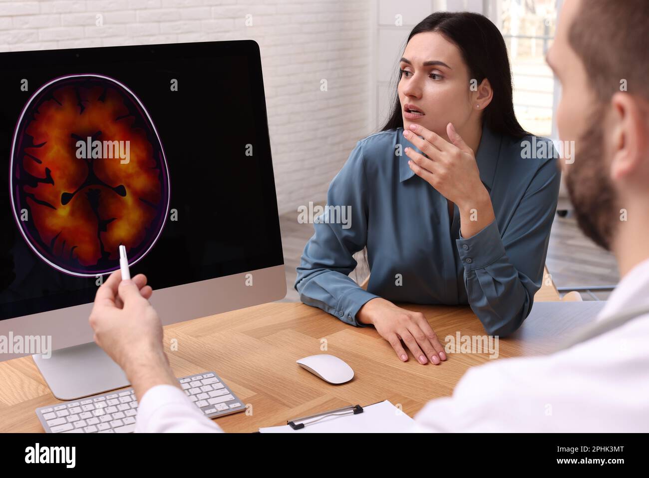 Neurologist showing brain scan to young woman in clinic Stock Photo - Alamy