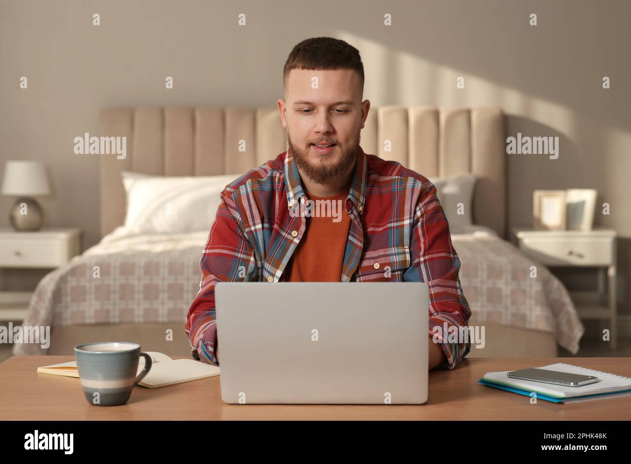 Online test. Man studying with laptop at home Stock Photo - Alamy
