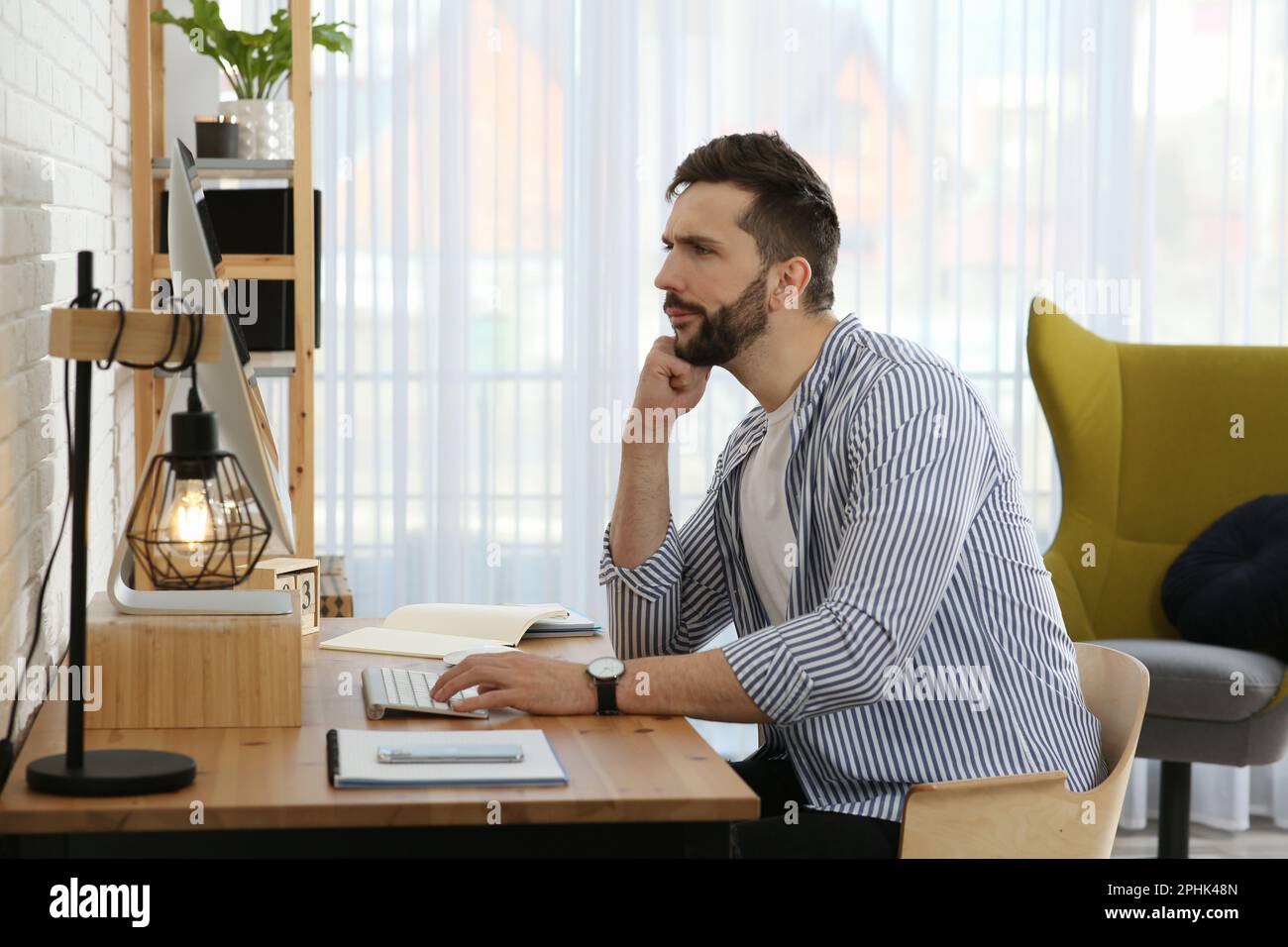 Online test. Man studying with computer at home Stock Photo - Alamy